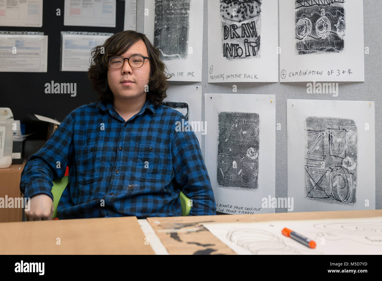 an international student stands by the art displays in the art room ...