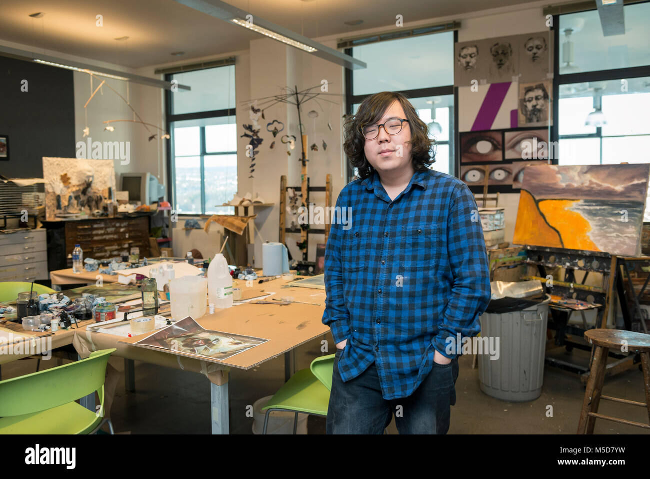 an international student stands by the art displays in the art room ...