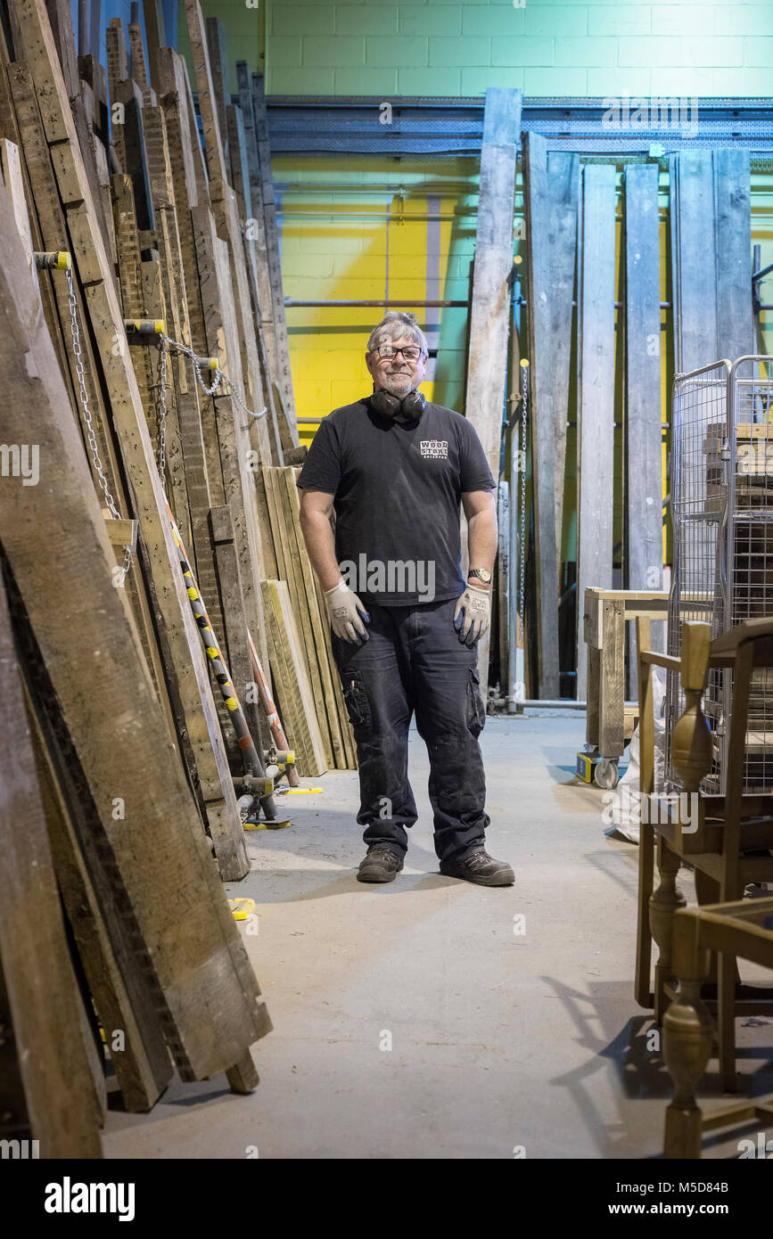 a man stands on the work shop floor of a wood working and supply ...