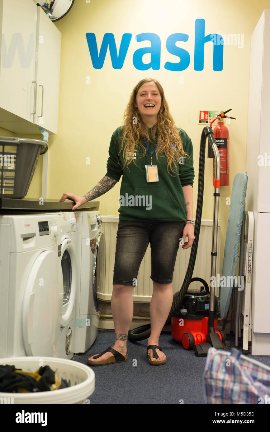 a woman from a homeless charity in brighton stands in the laundry ...