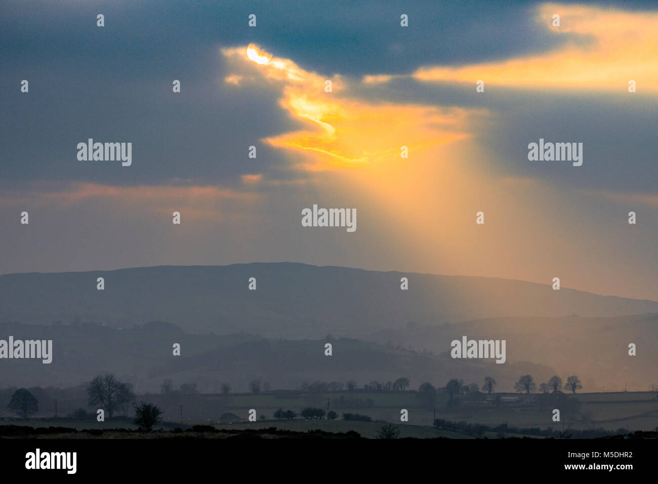 A dramactic lanscape in Wales at sunset as Crepuscular rays break ...