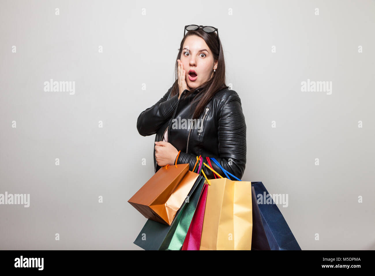 Surprised shocked girl in studio with shopping bags Stock Photo - Alamy