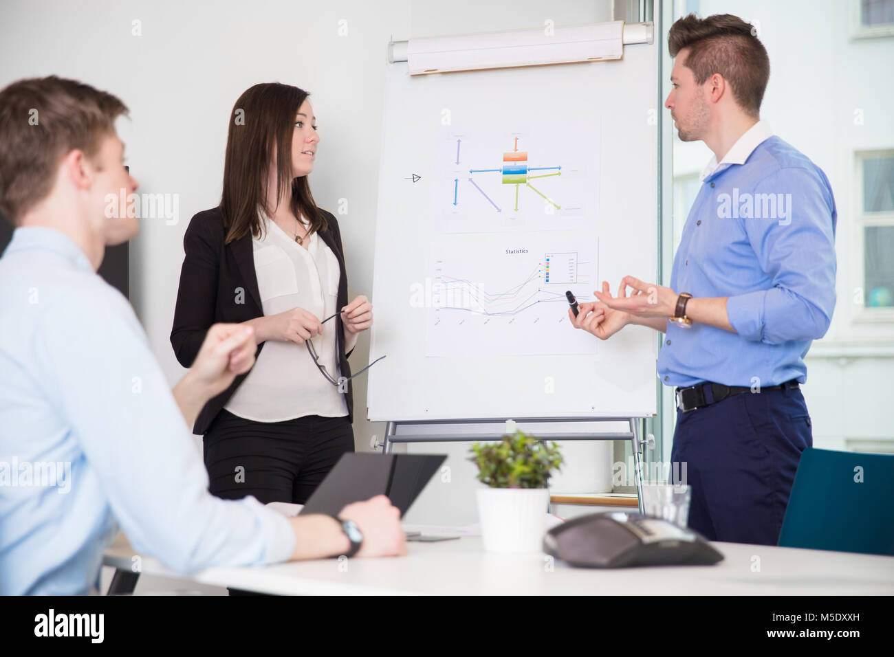 Executive Explaining Chart To Coworkers In Office Stock Photo - Alamy