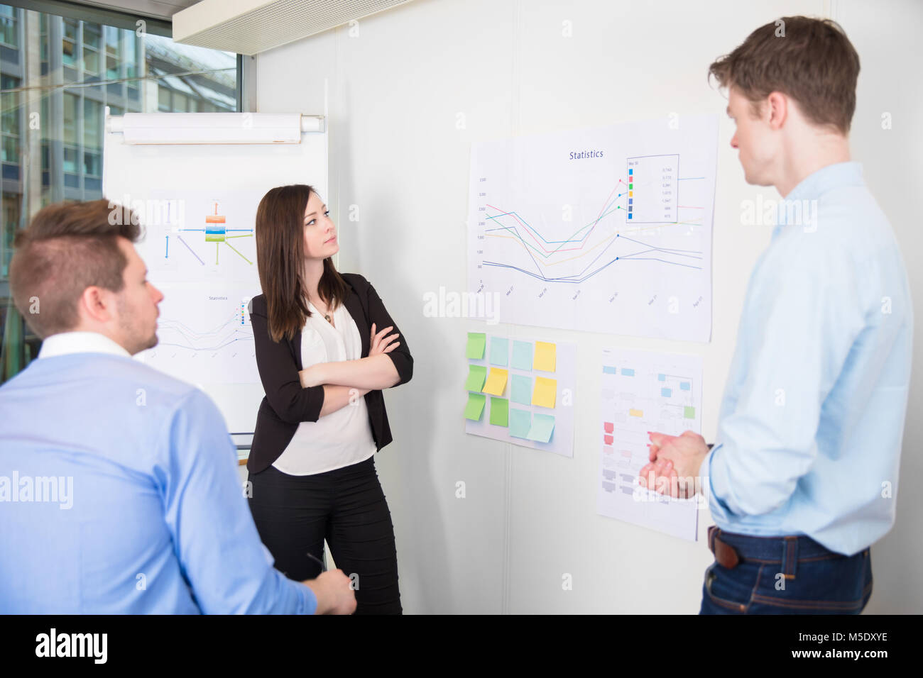 Business People Discussing Over Line Graph In Office Stock Photo - Alamy