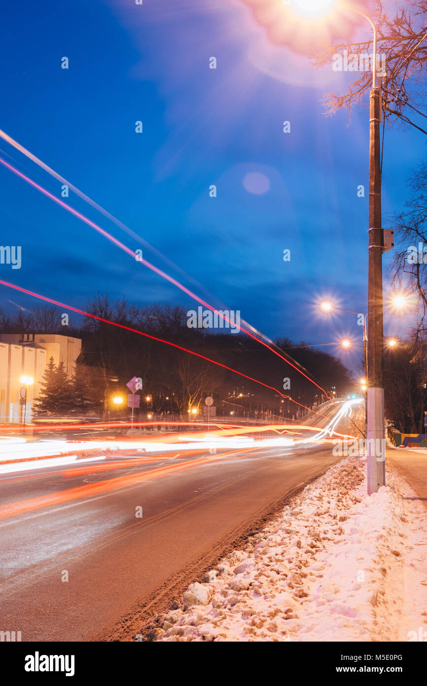 The road leaving down with tracks from automobile headlights on long ...