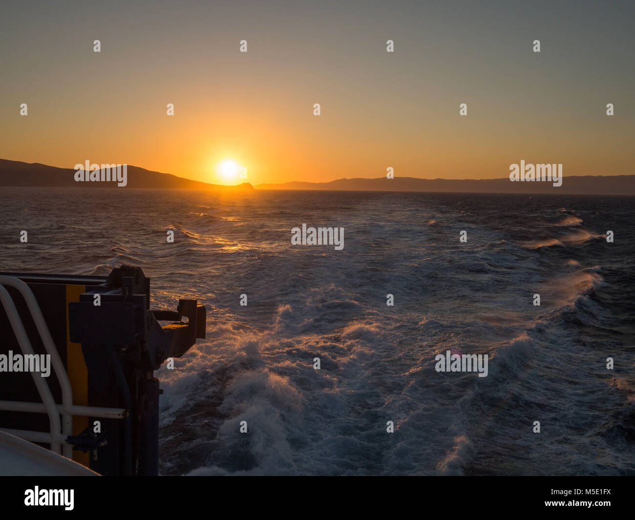 leaving the island with the ferry in the sunset Stock Photo - Alamy