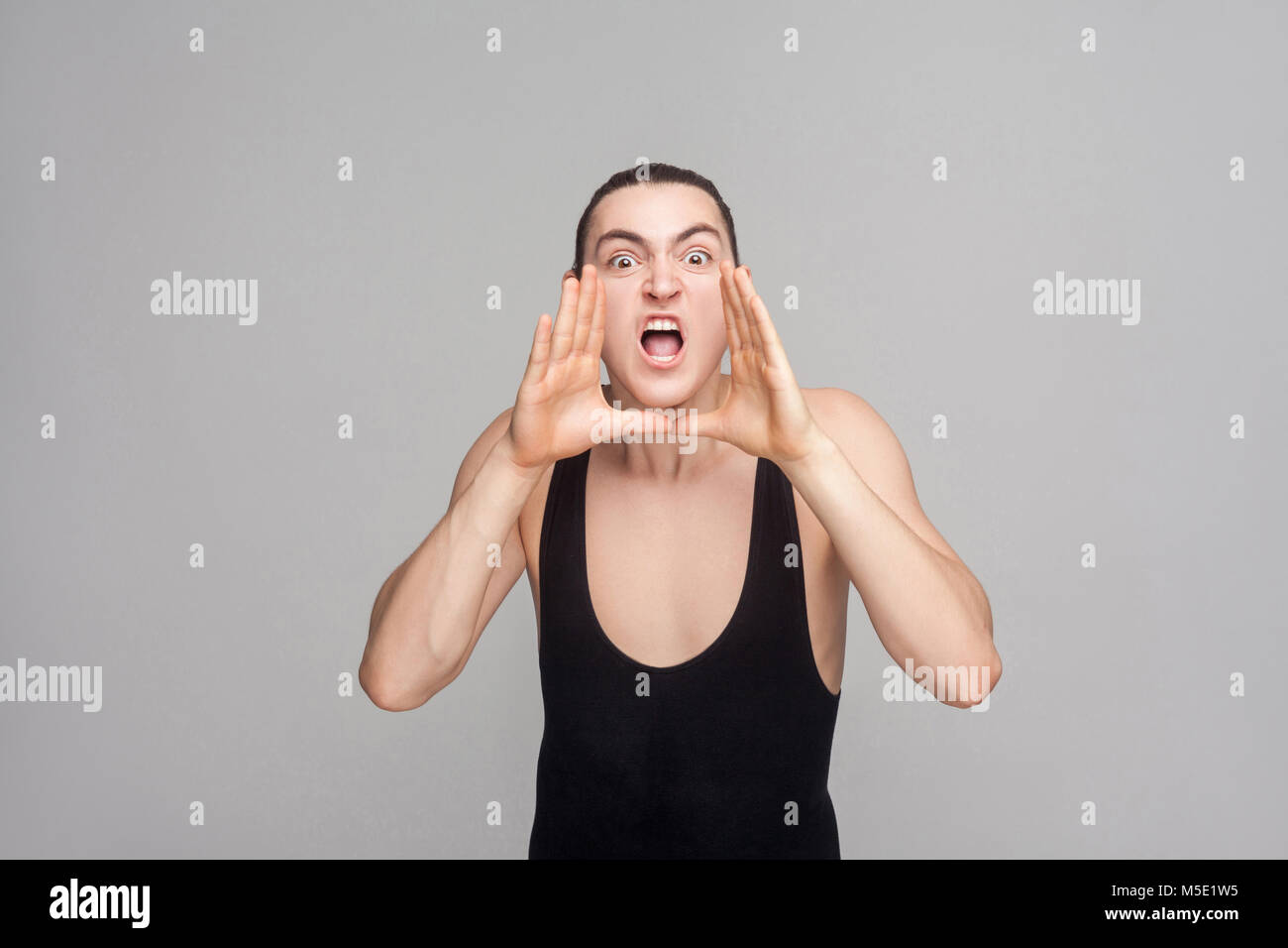 Anger man scream and shout at camera with big eyes. Studio shot ...