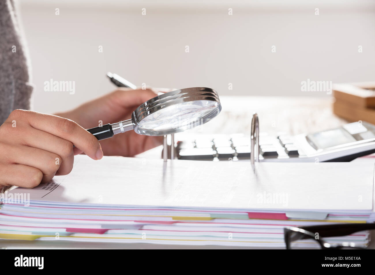 Close-up Of A Auditor Looking Invoice Through Magnifying Glass On Desk ...