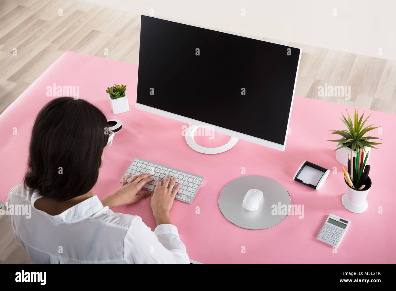 Elevated View A Businesswoman Typing On Keyboard Over The Pink Office ...