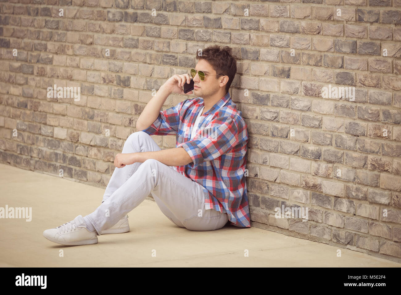 Young modern man chilling out and using mobile phone outdoors Stock ...