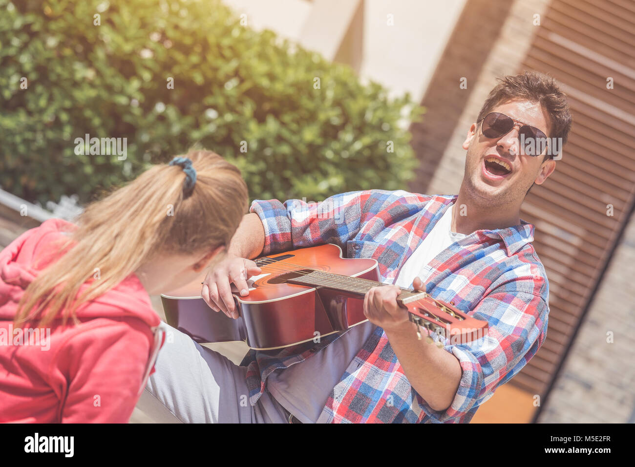 Romantic man singing song and playing guitar to his girlfriend in the ...
