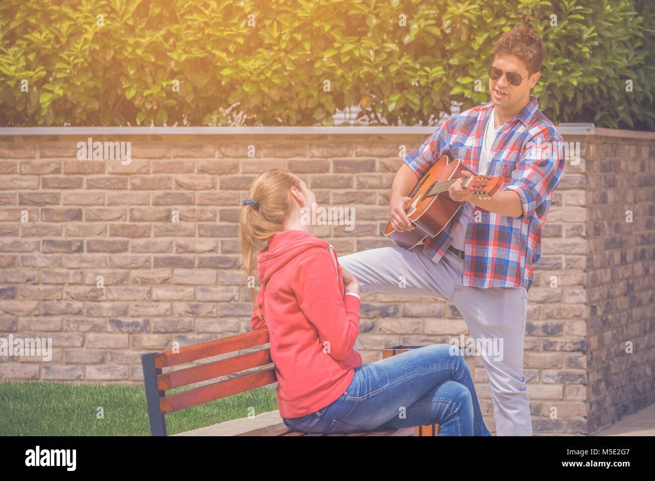 Romantic man singing song and playing guitar to his girlfriend in the ...