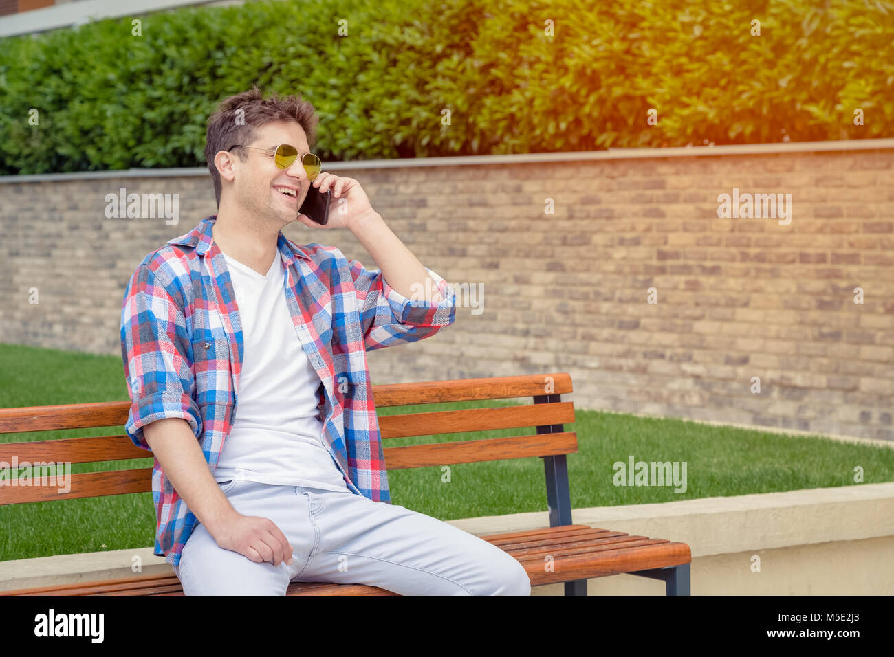 Urban guy making a call by using his smartphone outdoors Stock Photo ...