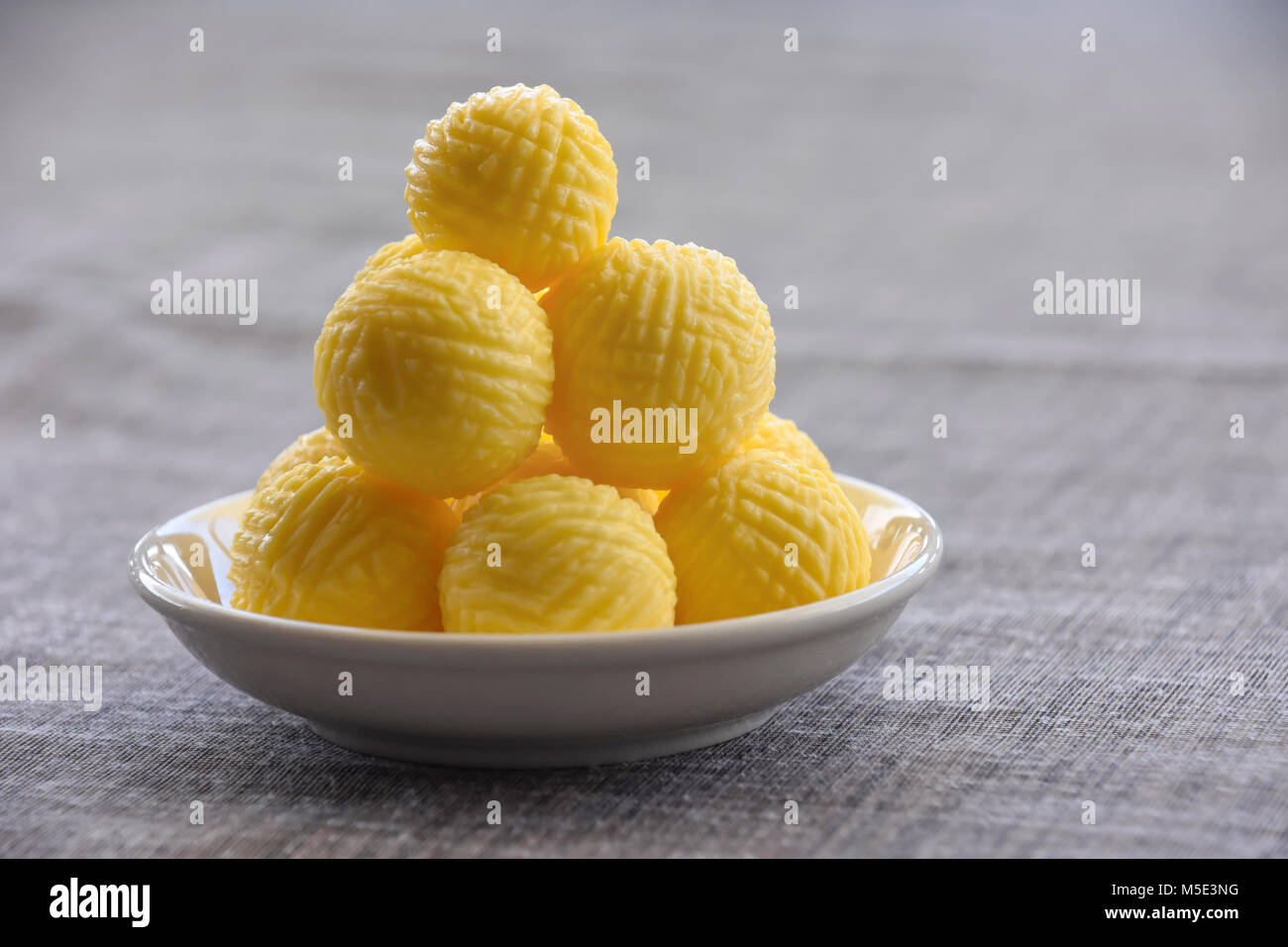 Nicely decorated balls made of margarine or butter placed on a grey ...