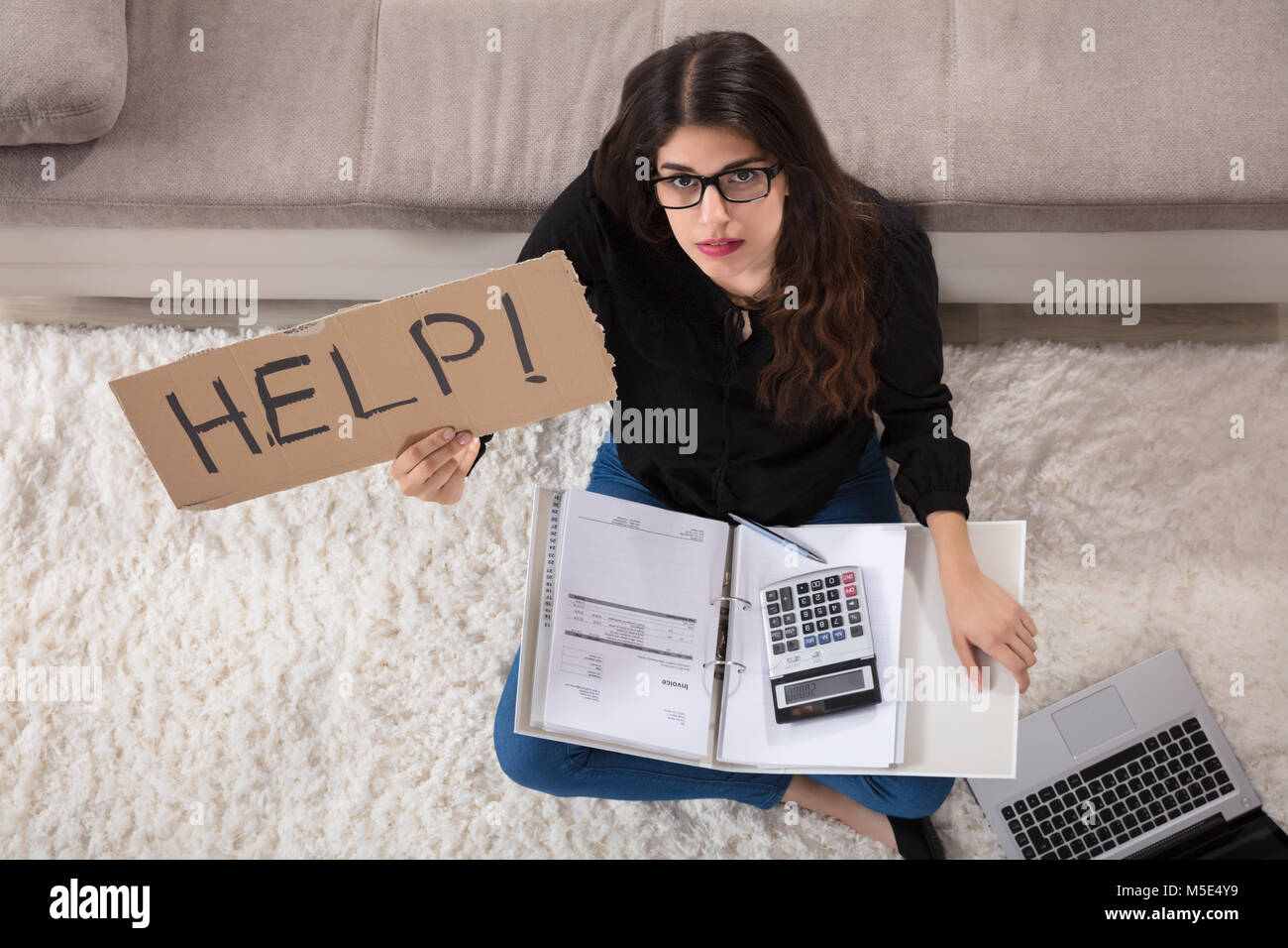 Sad Young Woman Holding Help Sign While Calculating Bills At Home Stock ...