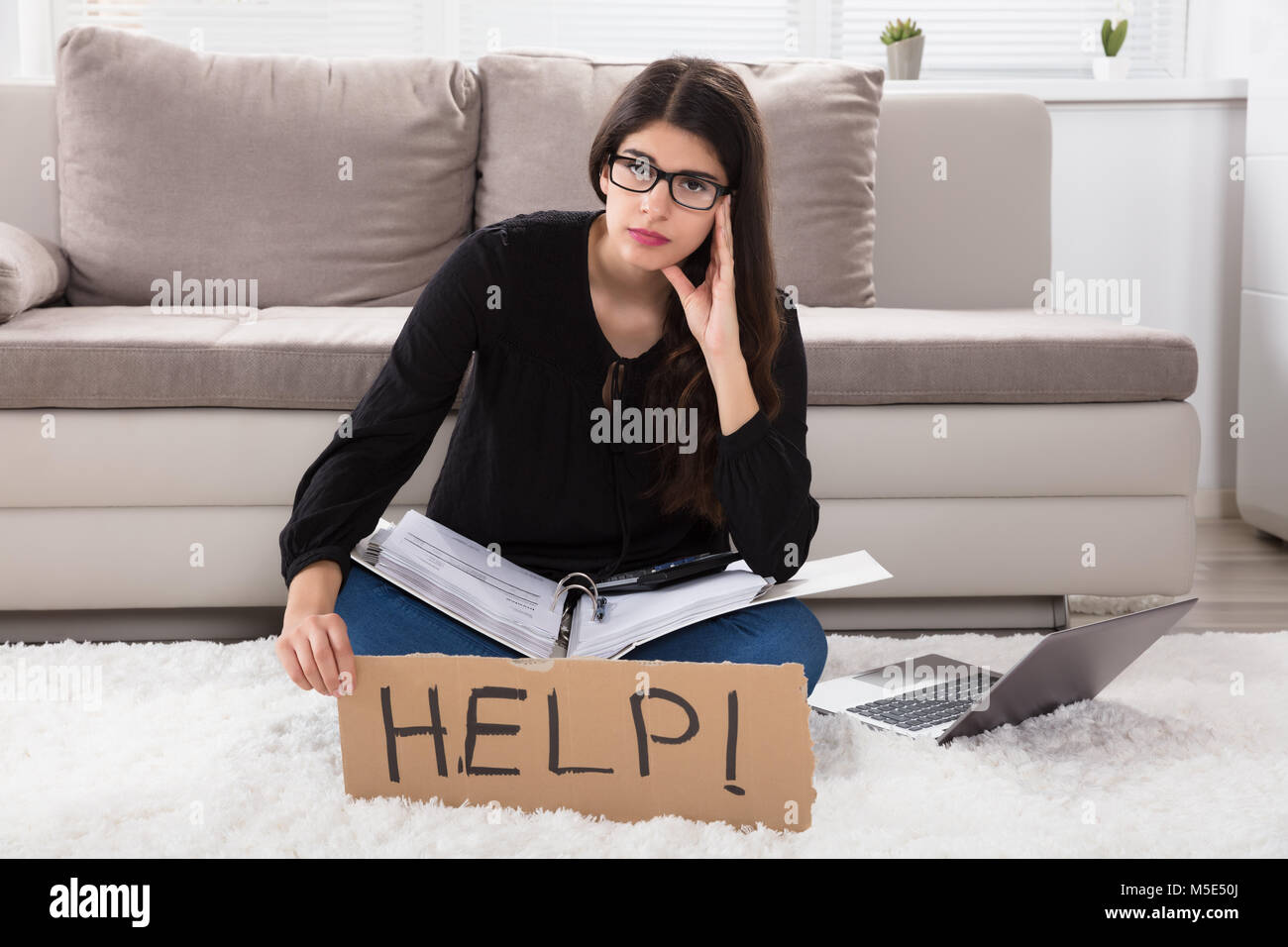 Sad Young Woman Holding Help Sign While Calculating Bills At Home Stock ...