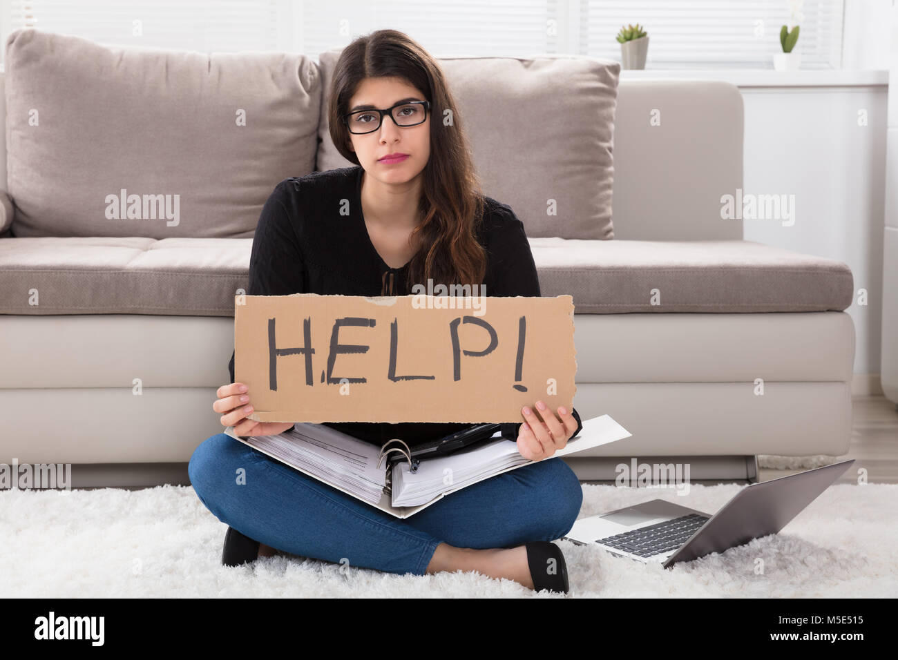 Sad Young Woman Holding Help Sign While Calculating Bills At Home Stock ...
