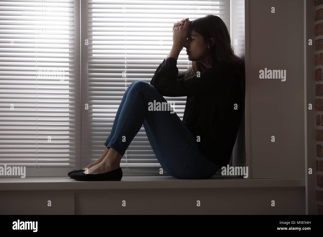 Young woman sad window hi-res stock photography and images - Alamy