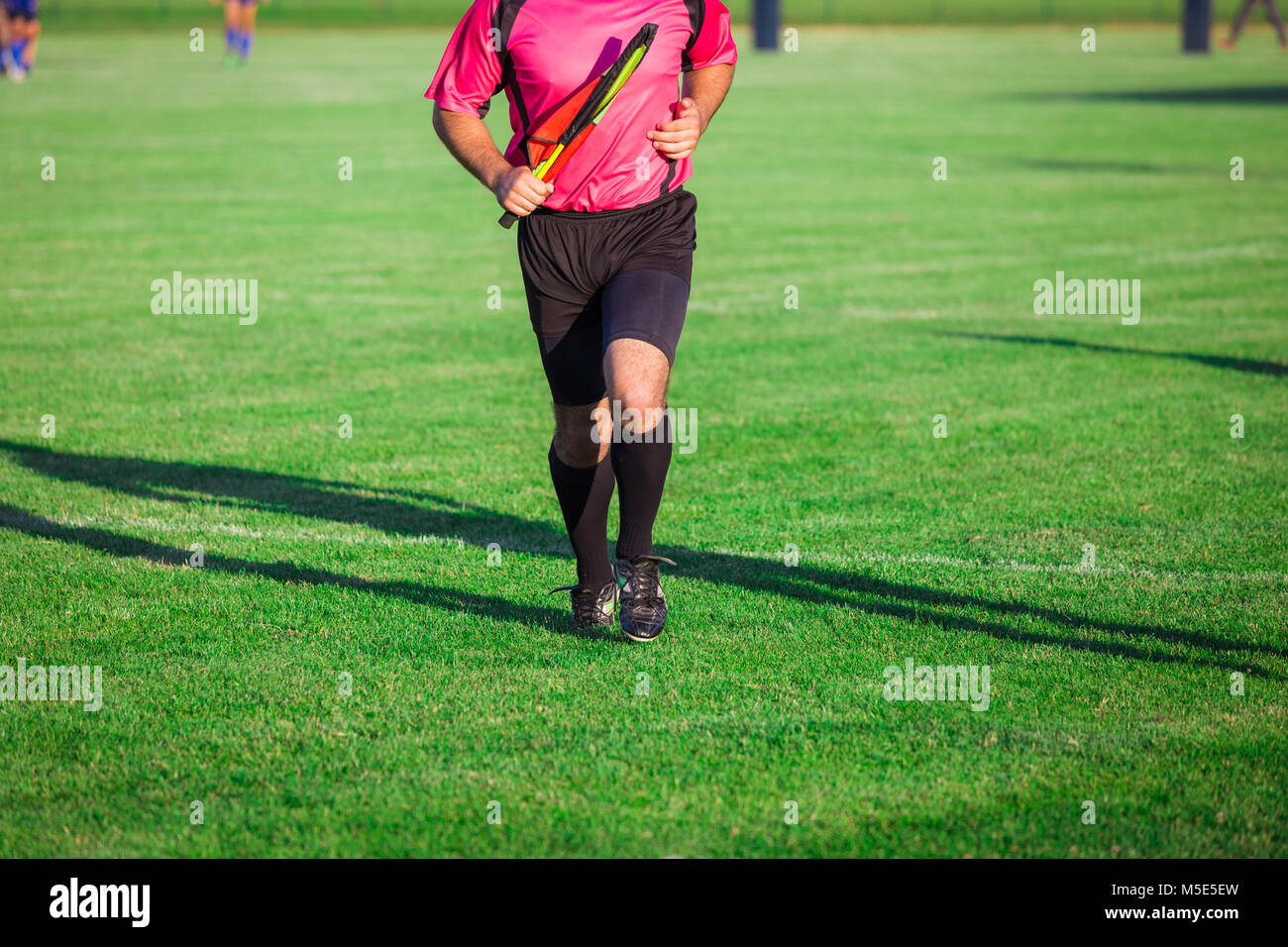 Football soccer rugby referee running on sport field and holding flag ...