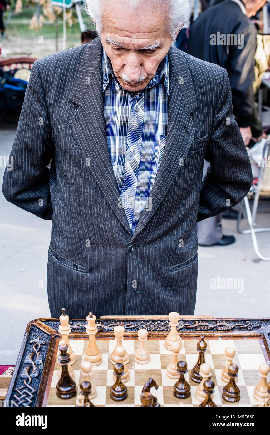Old man playing a game of chess at the flea market of Yerevan, Armenia ...