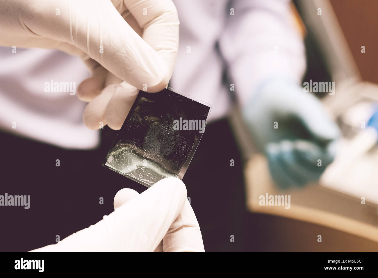 The investigator takes fingerprints from the suspect in the crime ...