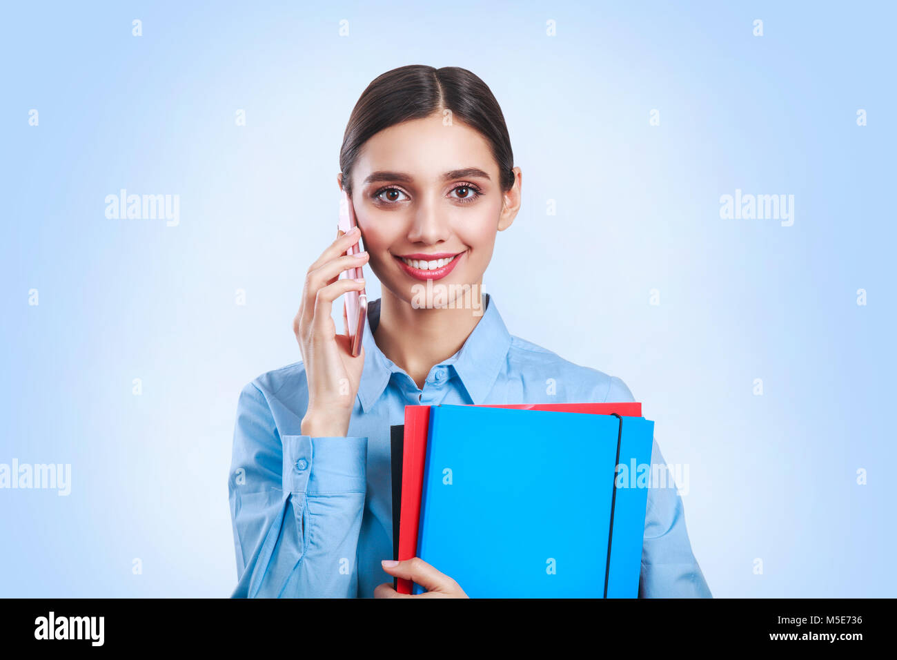 Successful businesswoman or entrepreneur taking notes and talking on ...