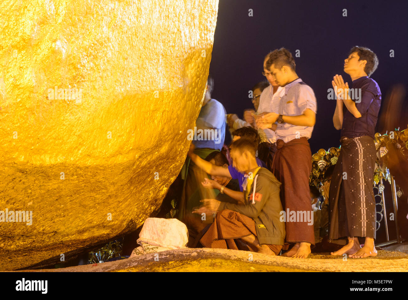 Kyaikto: mount Kyaiktiyo Pagoda (Golden Rock), men affix golden leaves ...