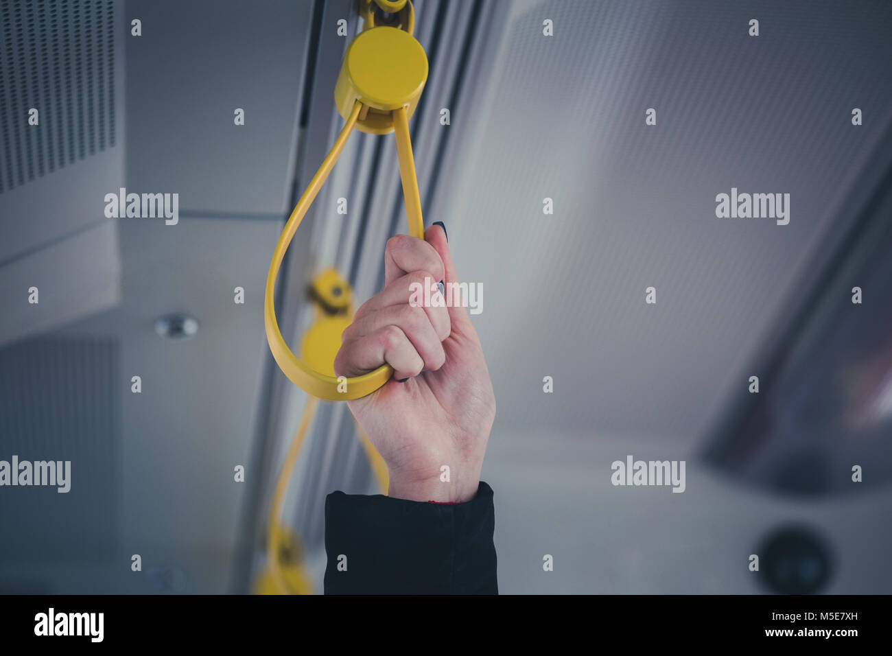 Close up of hand holding handle in bus, tram, metro or subway. Public ...