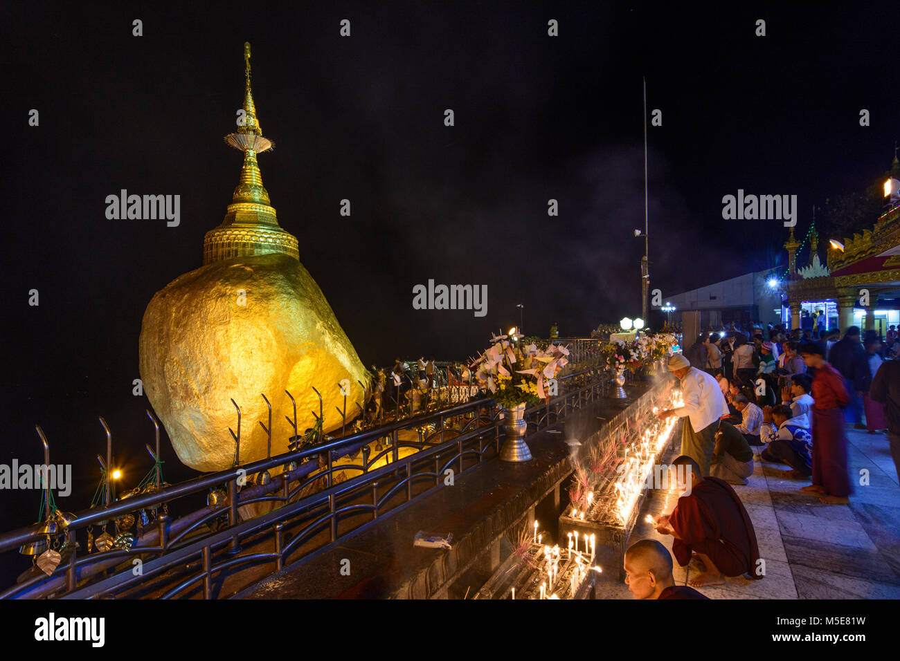 Kyaikto: mount Kyaiktiyo Pagoda (Golden Rock), people light candles ...