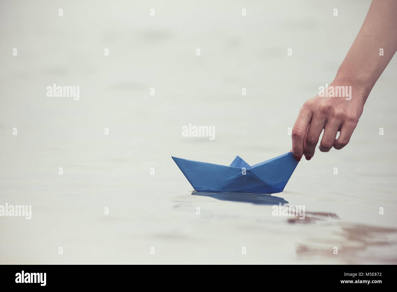 Female floating paper boat Stock Photo - Alamy