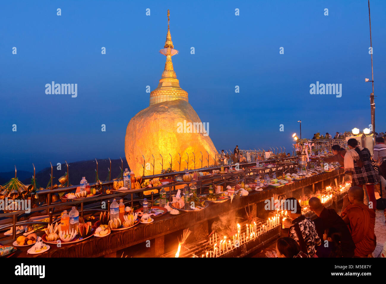 Kyaikto: mount Kyaiktiyo Pagoda (Golden Rock), people light candles ...
