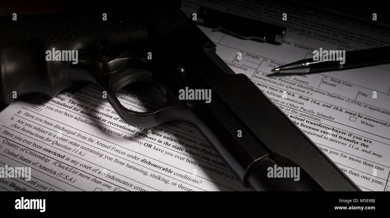 Gun and pen on firearm purchase paperwork with dishonorable discharge ...