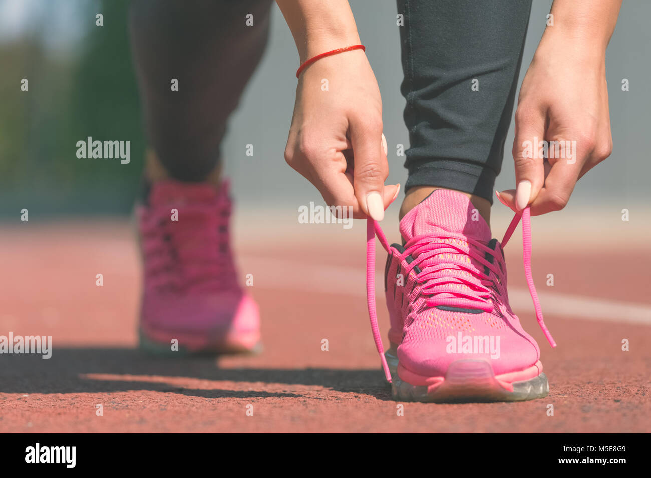 Running shoes - closeup of woman tying shoe laces. Female sport fitness runner getting ready for ...