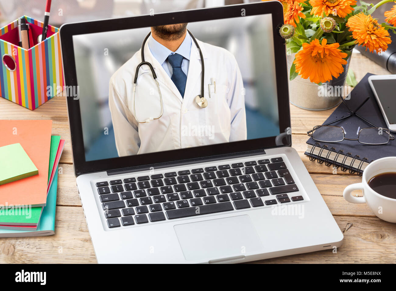 Telemedicine concept. Doctor GP on a computer screen, office desk ...