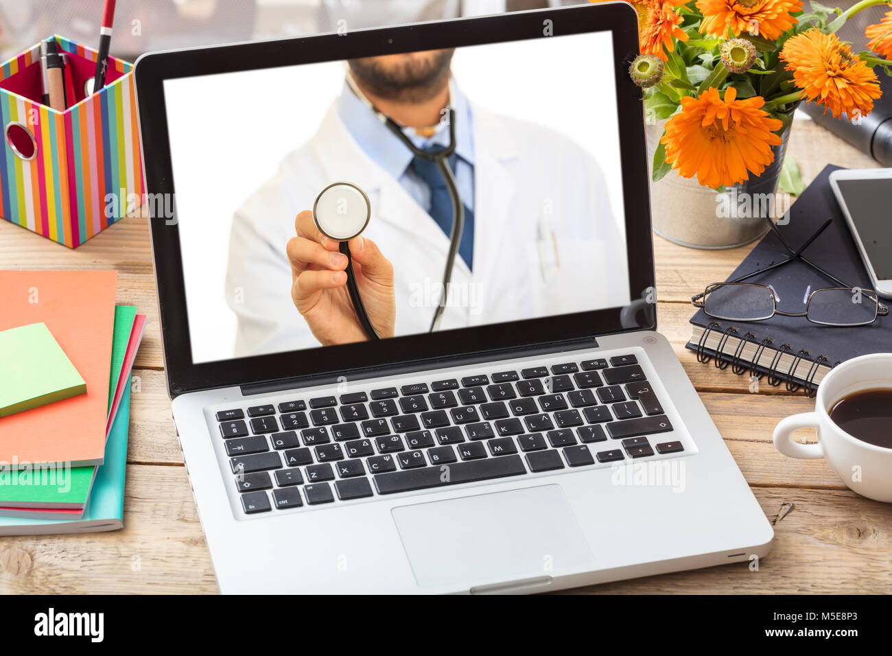 Telemedicine concept. Doctor GP on a computer screen, office desk ...