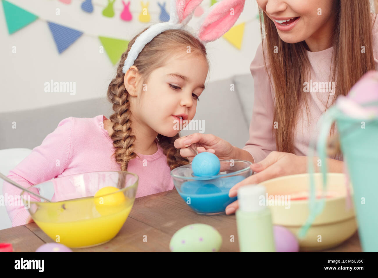 Mother and daughter together at home easter preparation in bunny ears ...