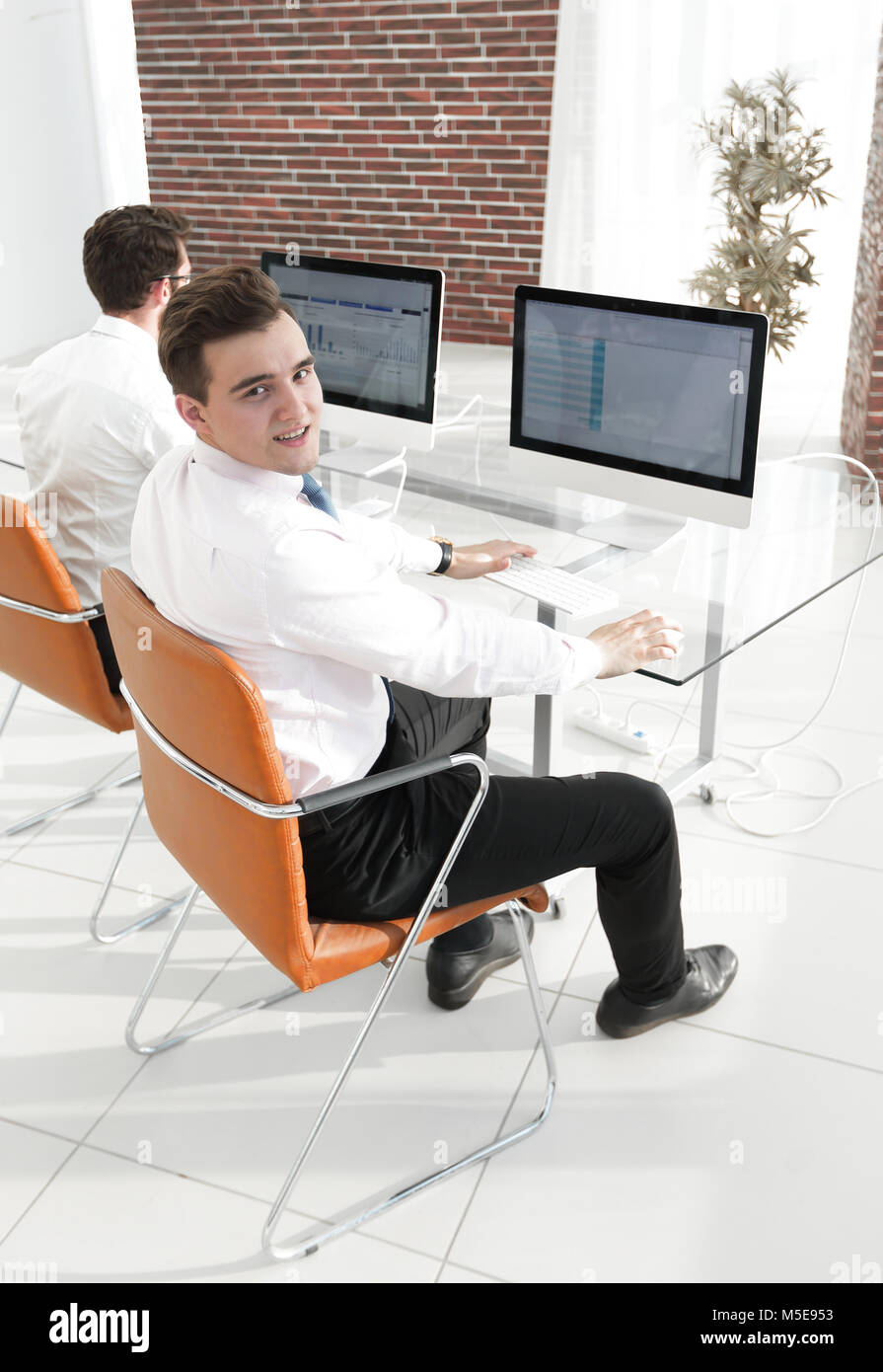 office life.employees sitting behind a Desk Stock Photo - Alamy