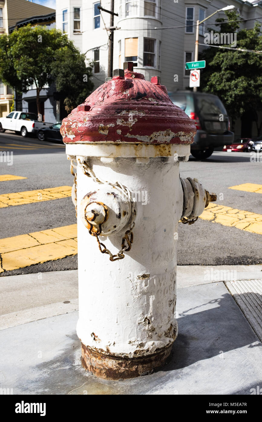 An old vintage fire water hydrant painted white and red on the corner ...