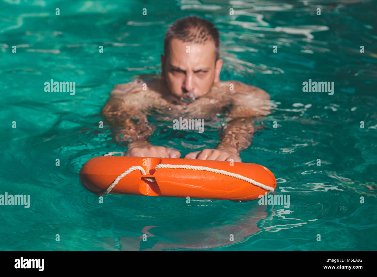 Swimmer using lifebuoy in water. Lifesaving concept Stock Photo - Alamy