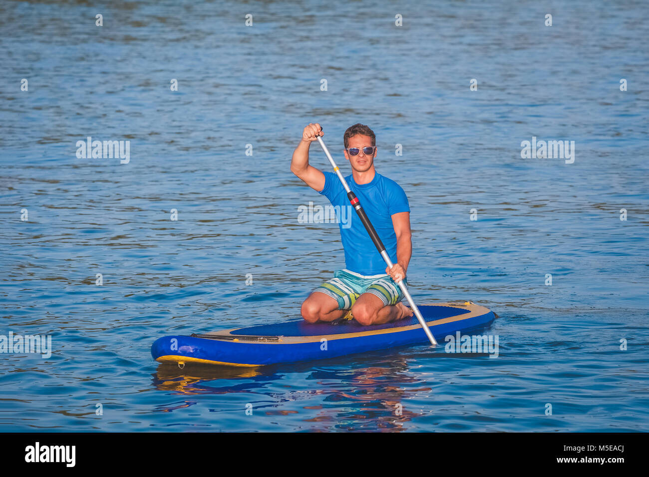 Portrait of young guy surfing on paddle board Stock Photo - Alamy