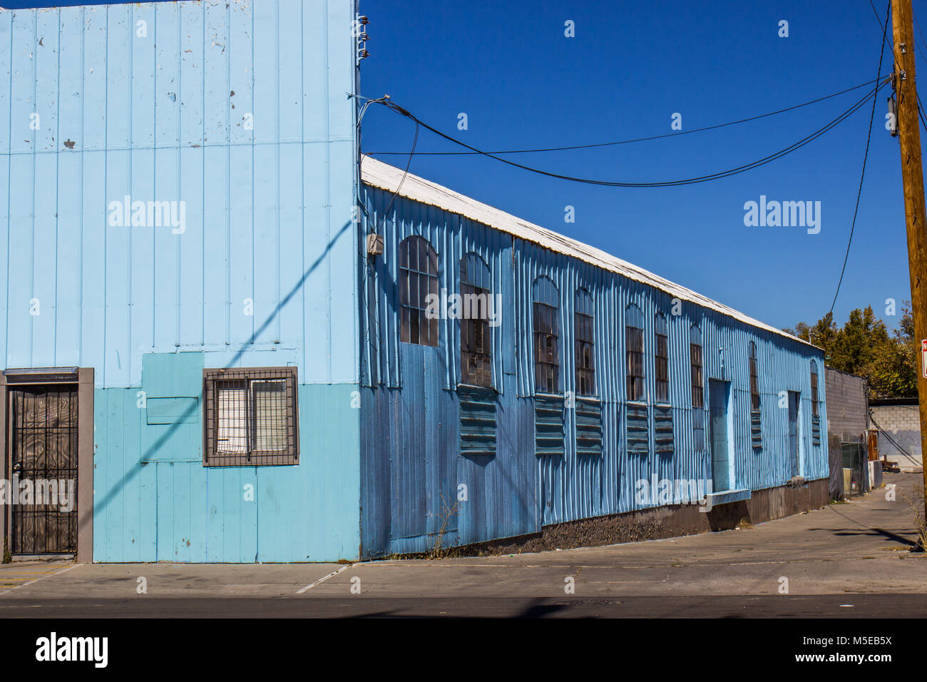 Side Of Old Boarded Up Light Blue Commercial Building Stock Photo - Alamy