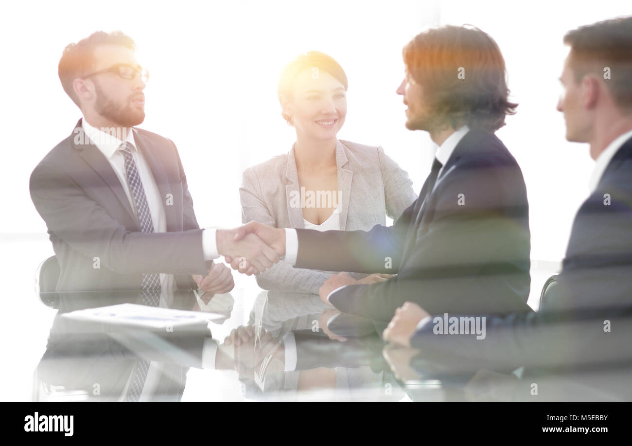 from behind the glass.handshake of business partners Stock Photo - Alamy