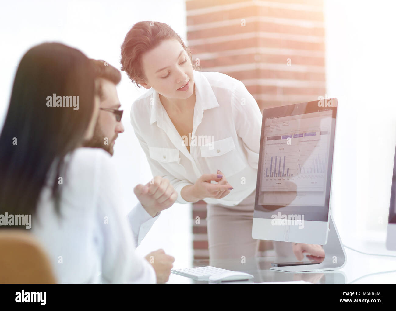specialists of the company discussing financial schedules at the desk ...