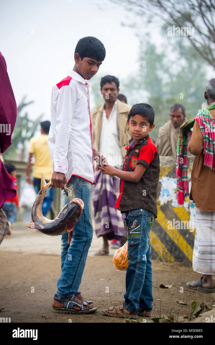 A young boy and his little brother is returning home after purchasing a ...