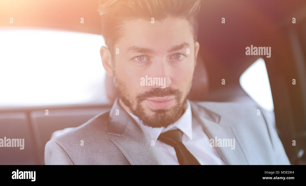 Businessman drinking coffee in the back seat of a car Stock Photo - Alamy
