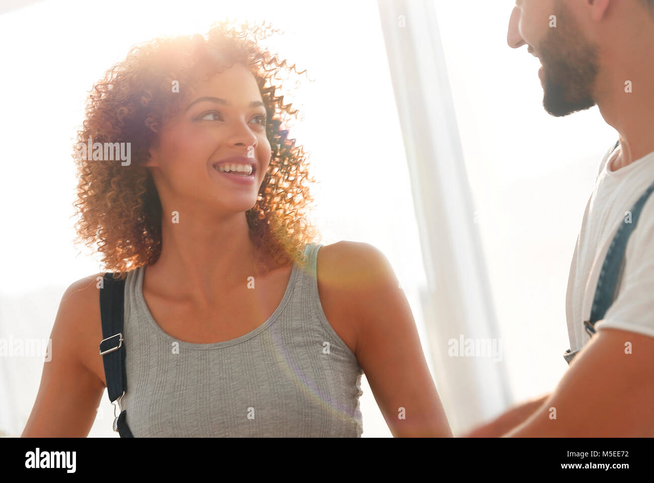Happy couple standing near the window Stock Photo - Alamy