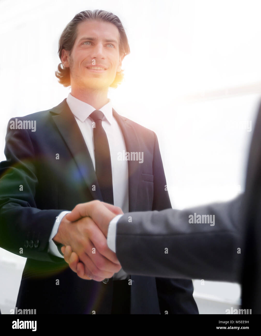 business group welcomes partner with a handshake Stock Photo - Alamy
