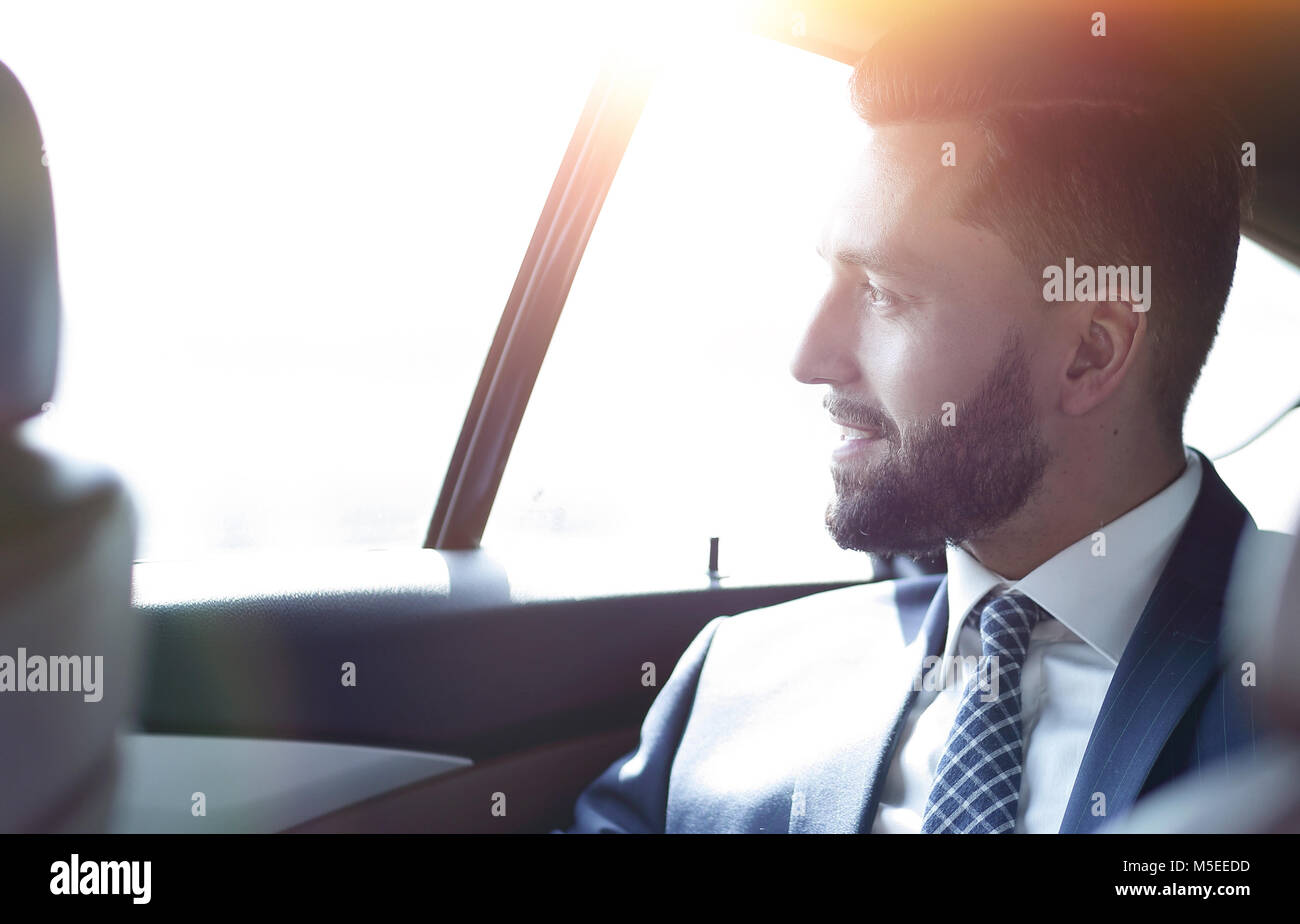 Smiling business man sitting in the back seat of a car Stock Photo - Alamy