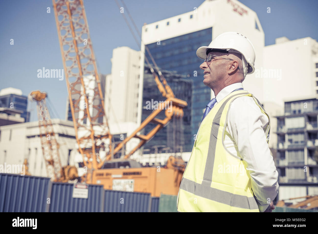 Senior foreman in glasses doing his job at building area on sunn Stock ...