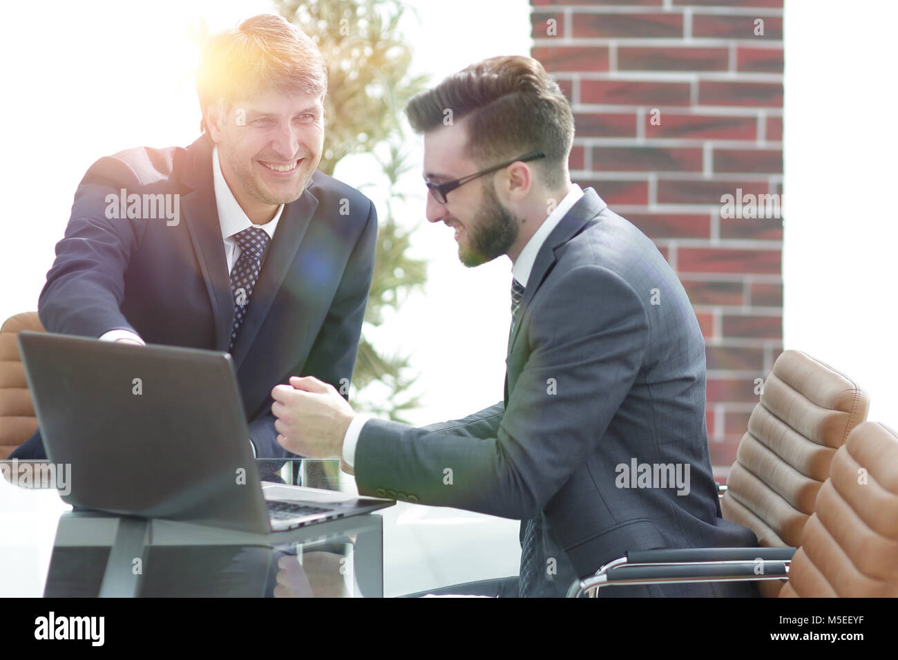 Two businessmen working together using laptop on business meeting in ...